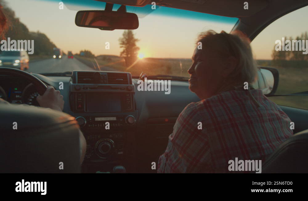 Two people travel in the car. Young man and elderly woman drive the car ...