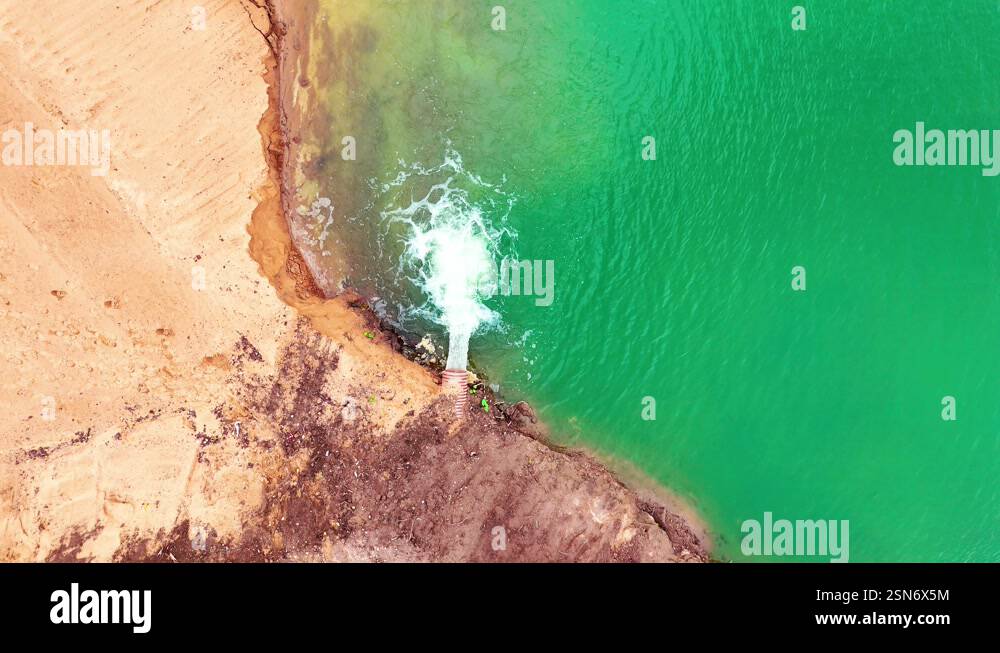 Wastewater discharge into a reservoir. Industrial wastewater flows from ...