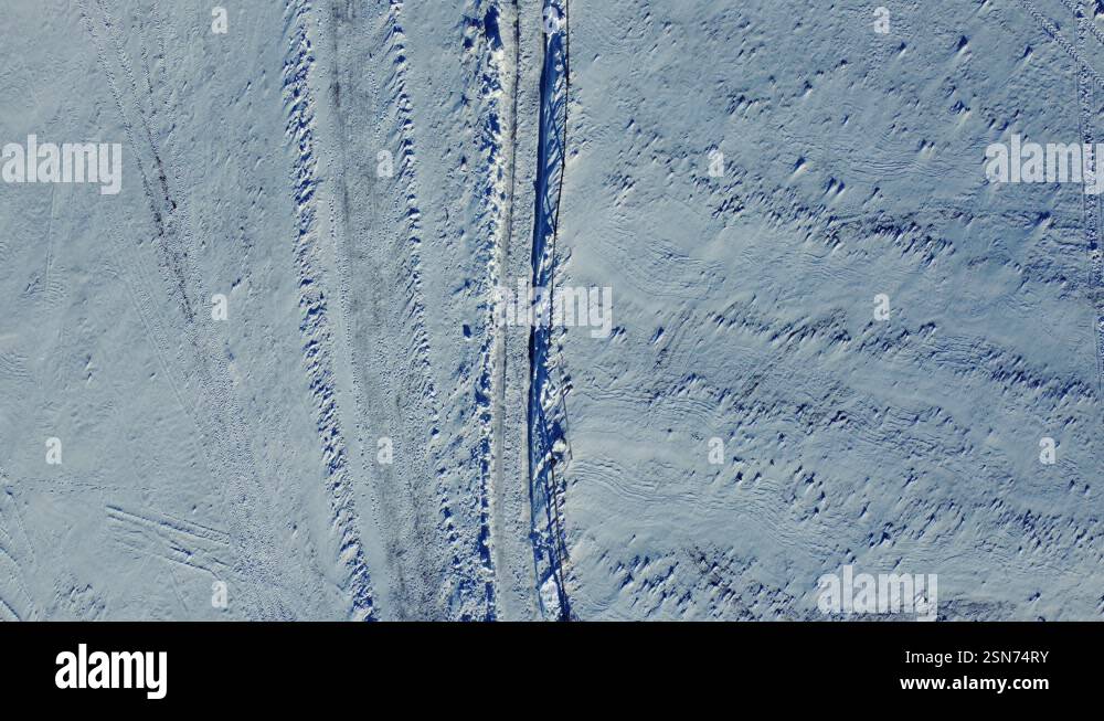 Aerial view of snow-covered tracks on an open field in Beskid Żywiecki ...