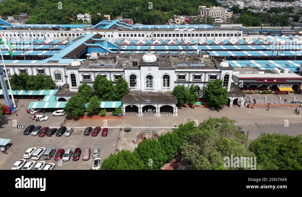 Wide-angle drone footage of a railway station with highway cutting ...