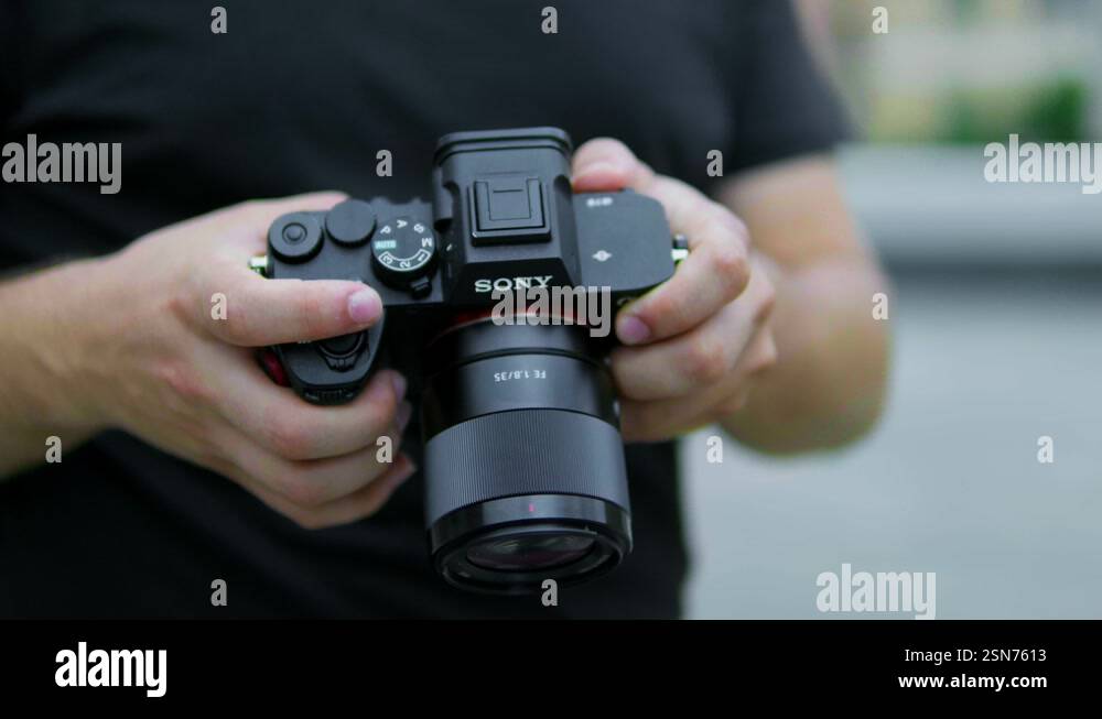 Genoa, Italy - 10/14/2024: Person holding a Sony mirrorless camera with ...