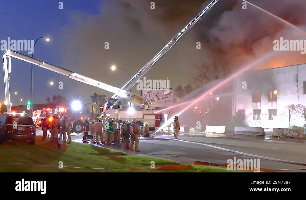 Fire Trucks and Firefighters are Extinguishing a Fire at a Burning ...