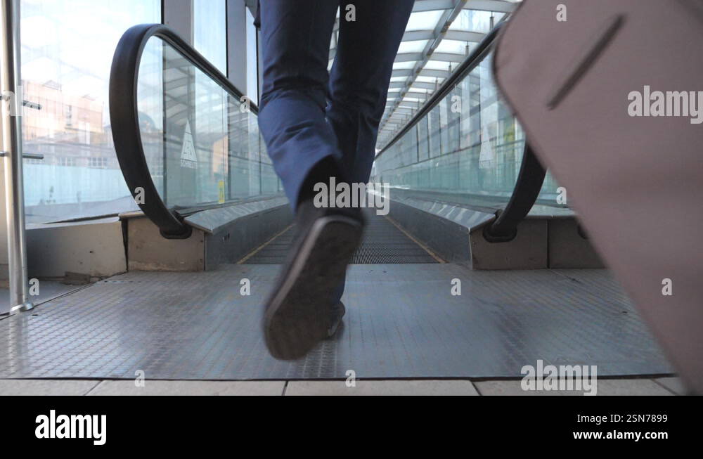 Legs of successful businessman running in hall of terminal and pulling ...