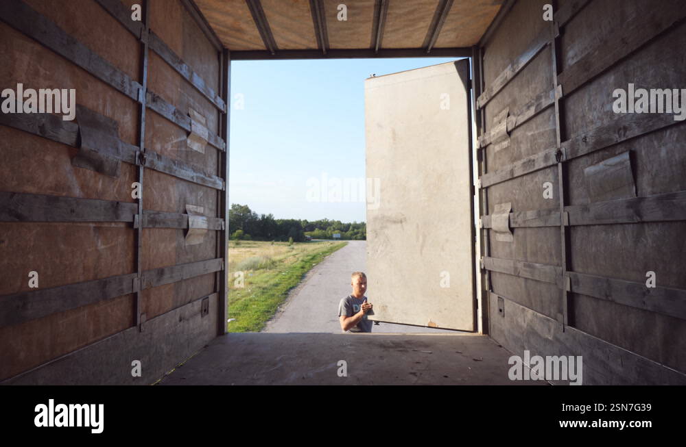 Driver opens the door of trailer at parked truck. Lorry inside Stock ...