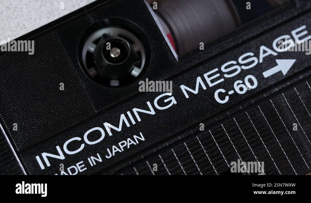 A vintage audio cassette spins on an incoming message label tape Stock ...