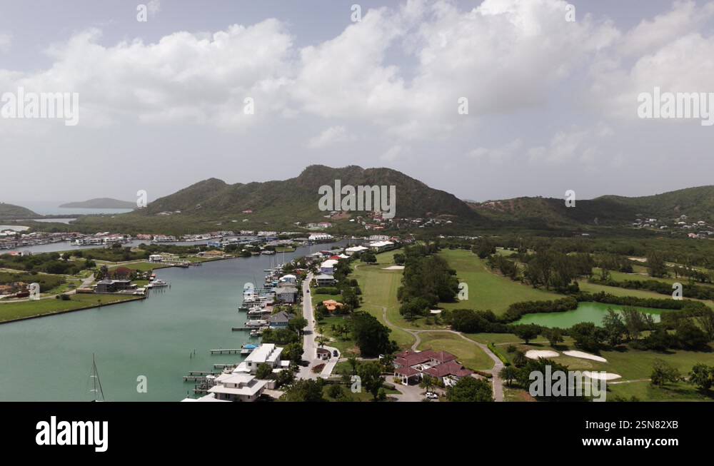 Jolly harbor, antigua with marina, golf course, and lush hills on a ...