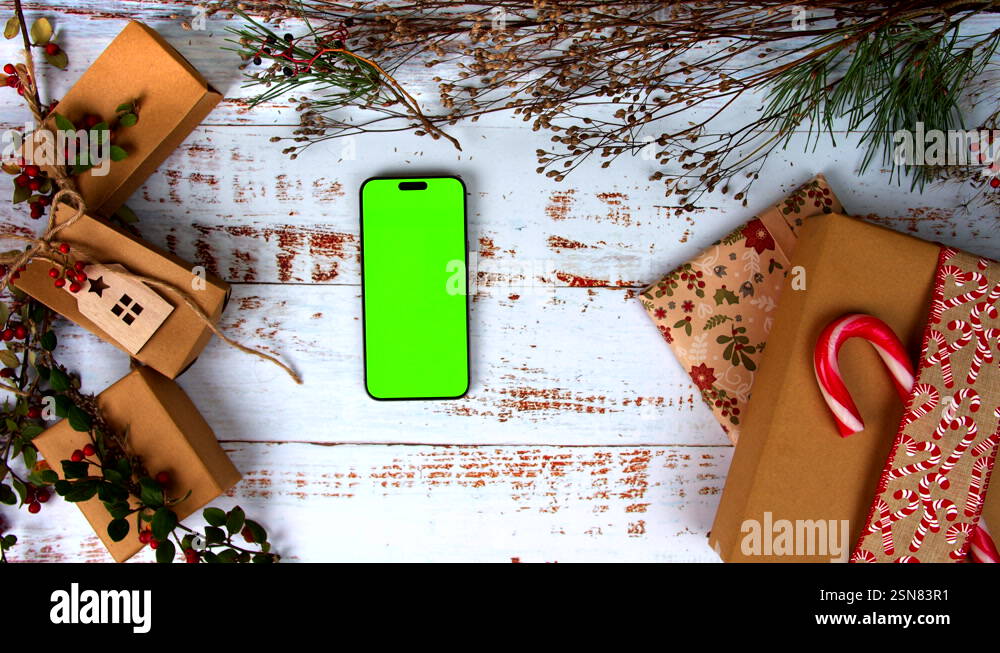 Hand using a static smartphone with a green screen mockup on a rustic ...