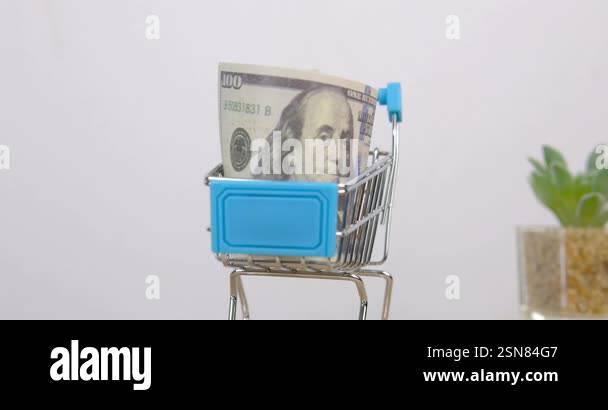 100 dollar bills in the shopping basket. close-up, spinning. Concept of ...