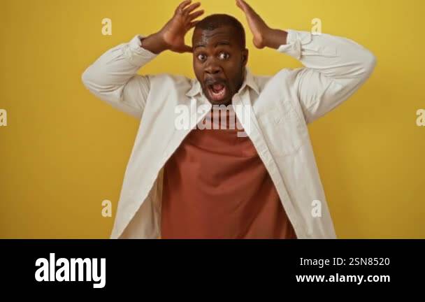 African american man standing with hands on head in shock, surprised ...