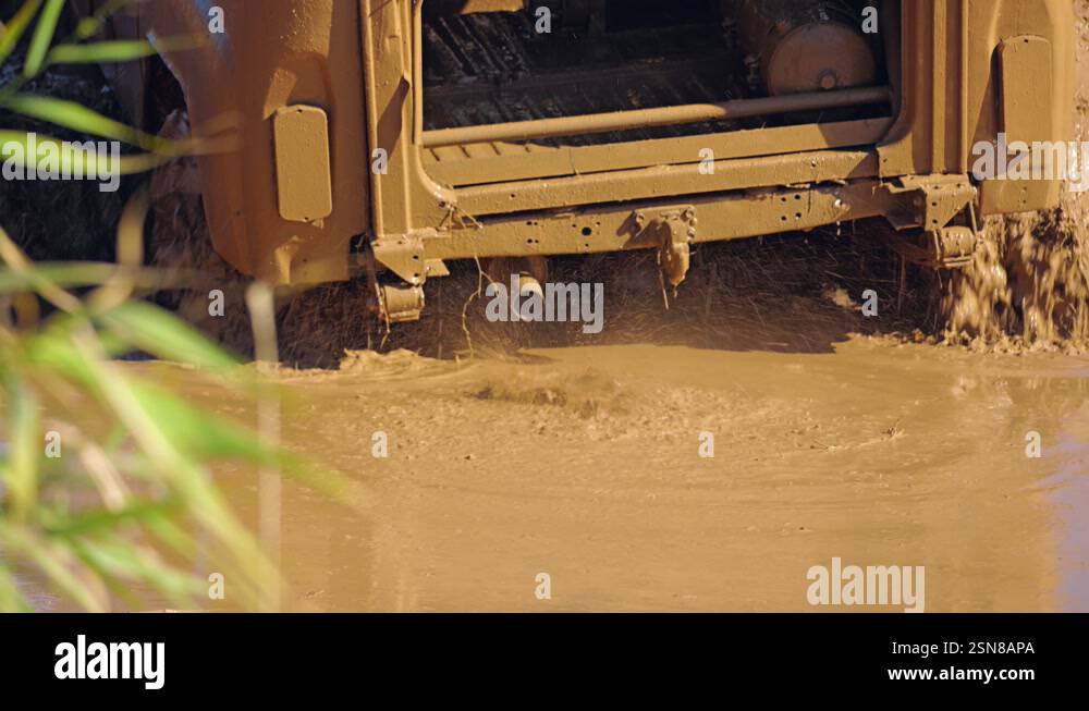 Close-up of the rear of an SUV stuck in a mud puddle, water and mud ...