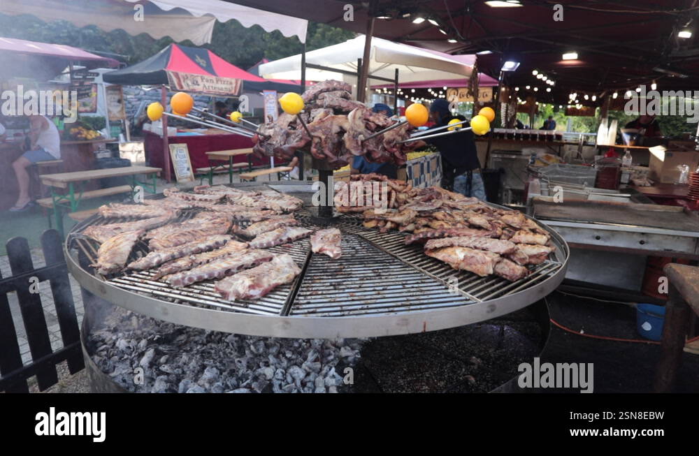 Vigo, Spain - 10/16/2024: Outdoor BBQ grill with various meats cooking ...