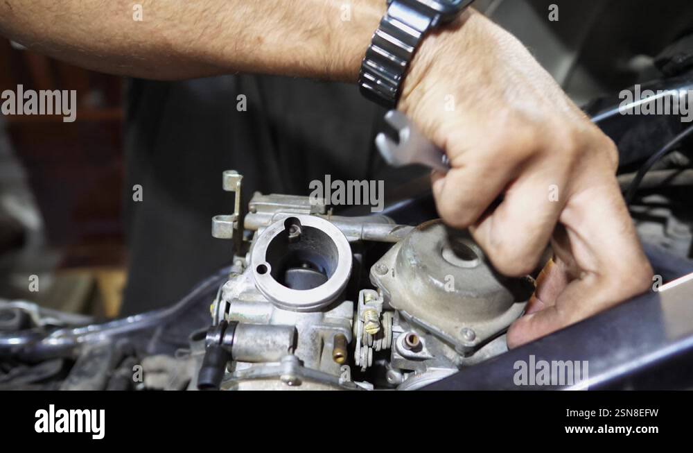 Male hands of repairer fixing motor of motorbike using tool at ...