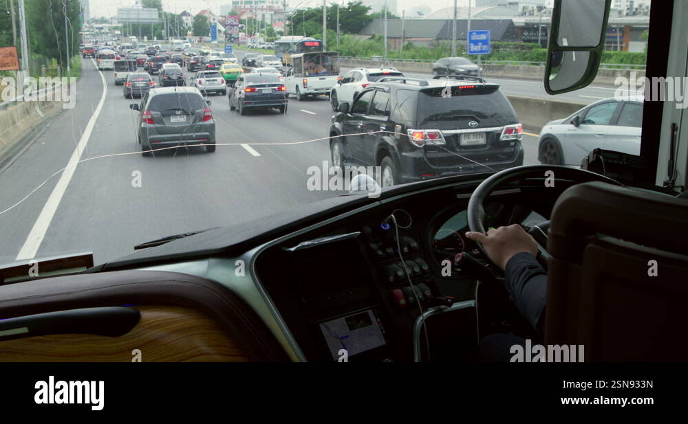 Bangkok, Thailand - 09/13/2024: A bus driver navigates an electric bus ...