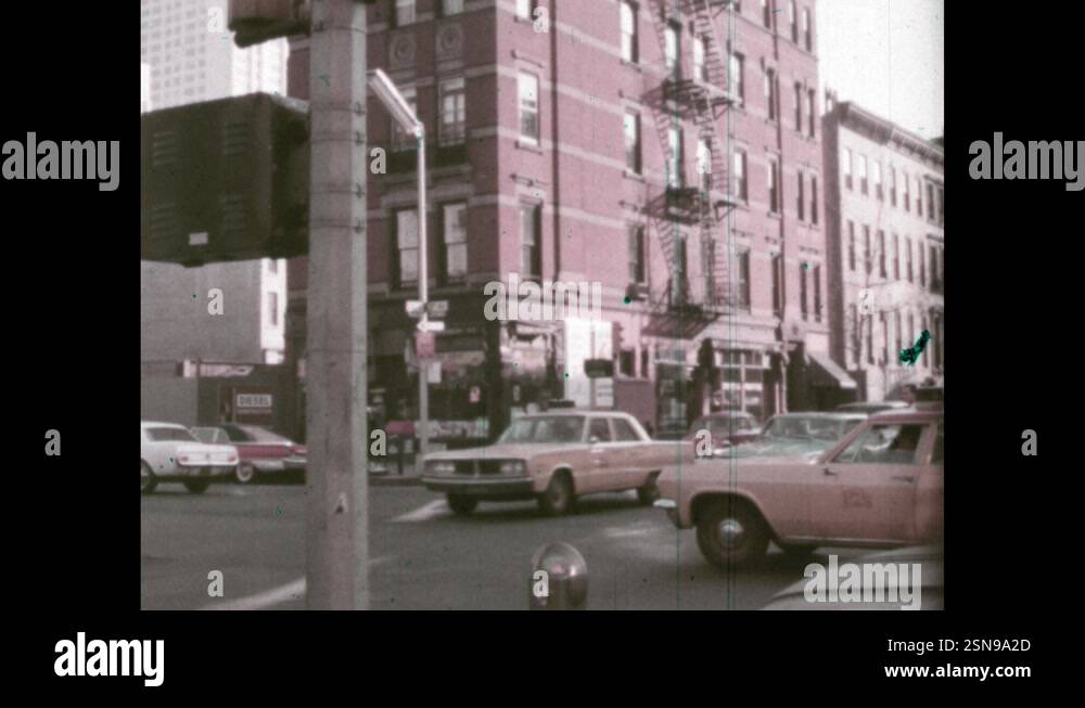 1960s: City street, traffic passing. View down street. Exterior of ...