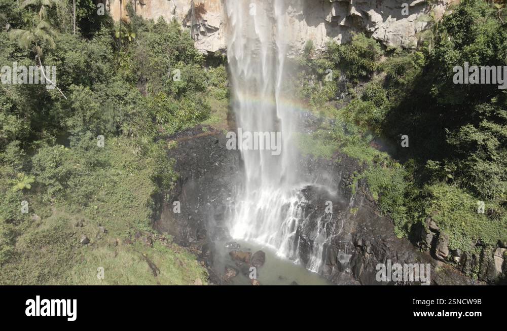 This huge jungle waterfall crashes through lush greenery, mist creating ...