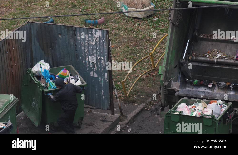 garbage workers load garbage and waste from containers into a garbage ...