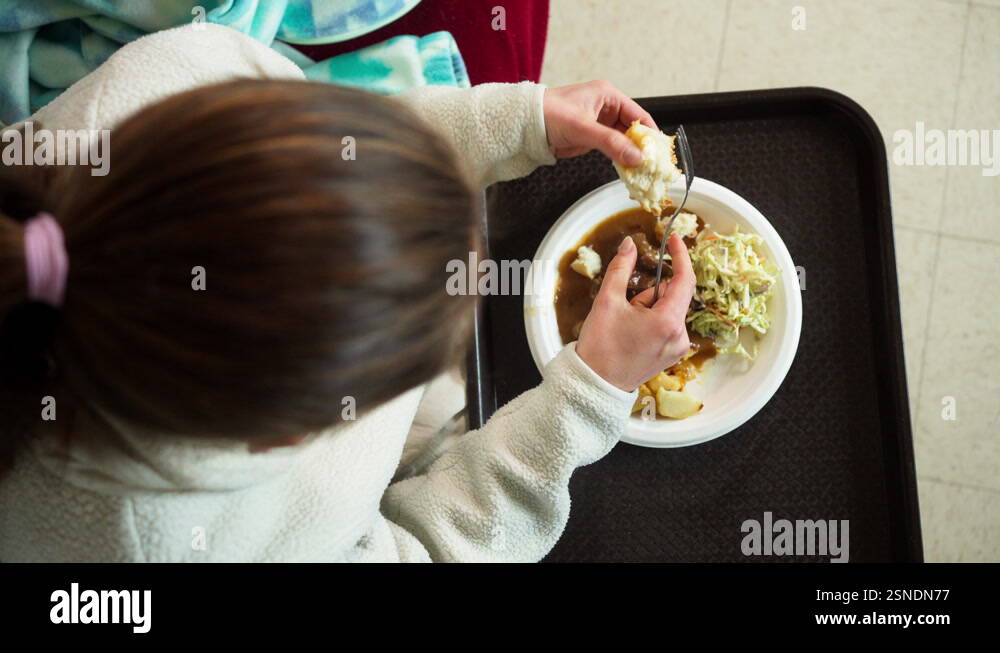 Inuit Woman Breaks The Bread While Eating Caribou Stew. - overhead shot ...