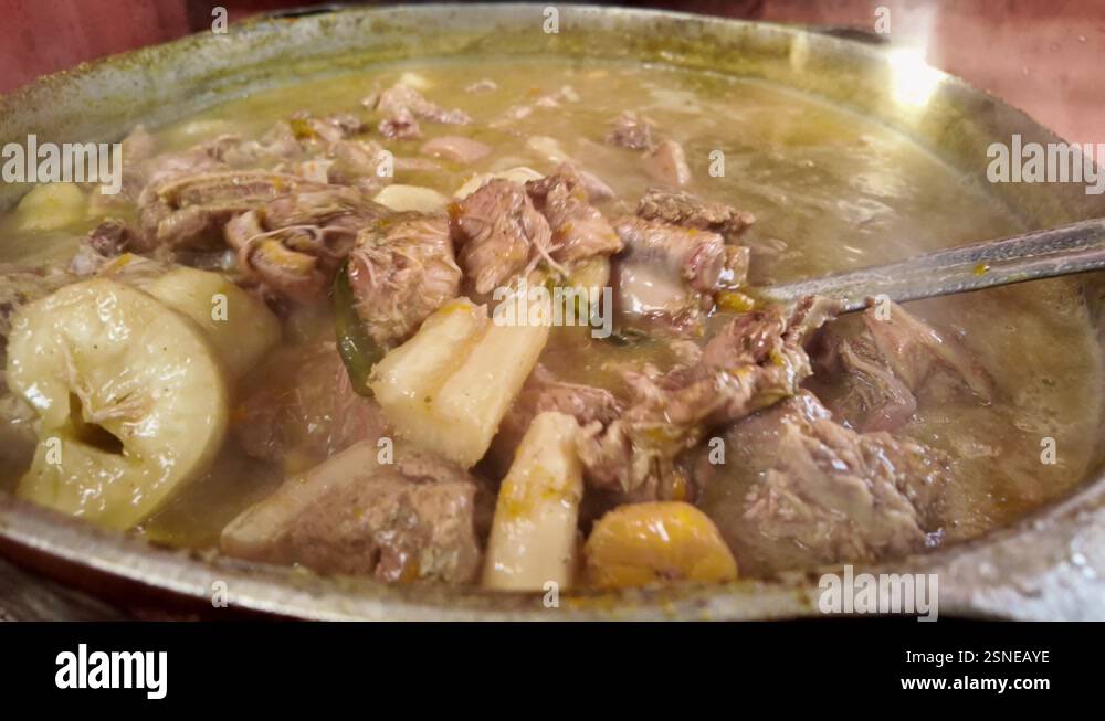 Ladle stirring traditional Dominican creole food called Sancocho, stew ...