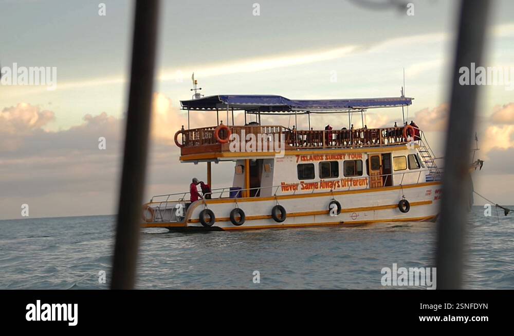 Pan from tour boat to traditional long tailed boat engine and captain ...