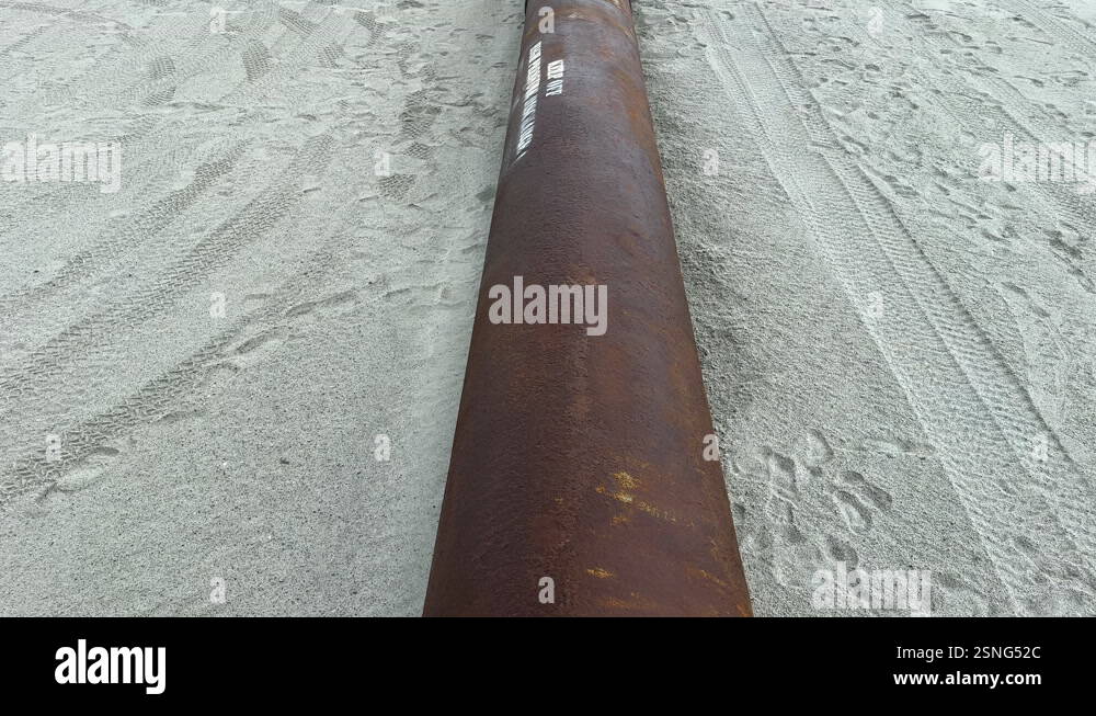 Pipe pumping sand from ocean during beach replenishment project Stock ...