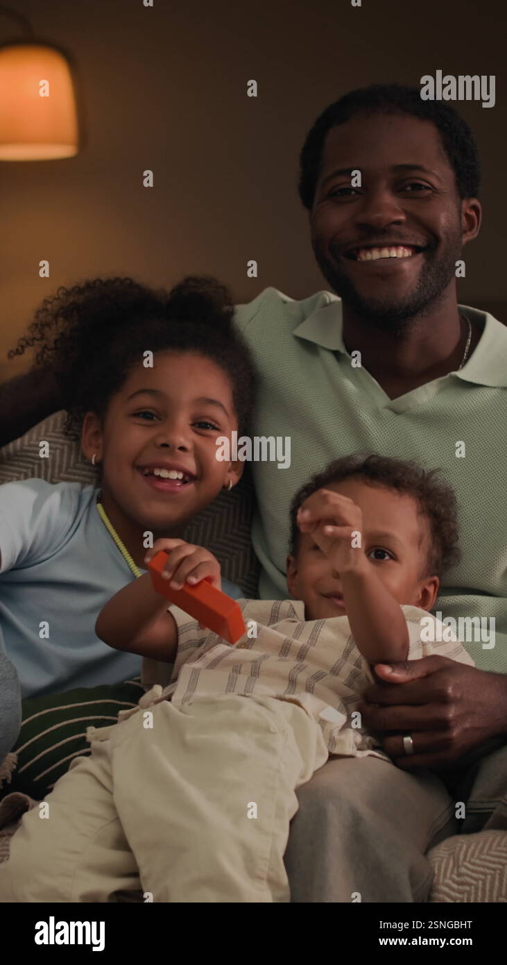 Vertical of Black Dad and His Children Enjoying Watching TV on Couch ...