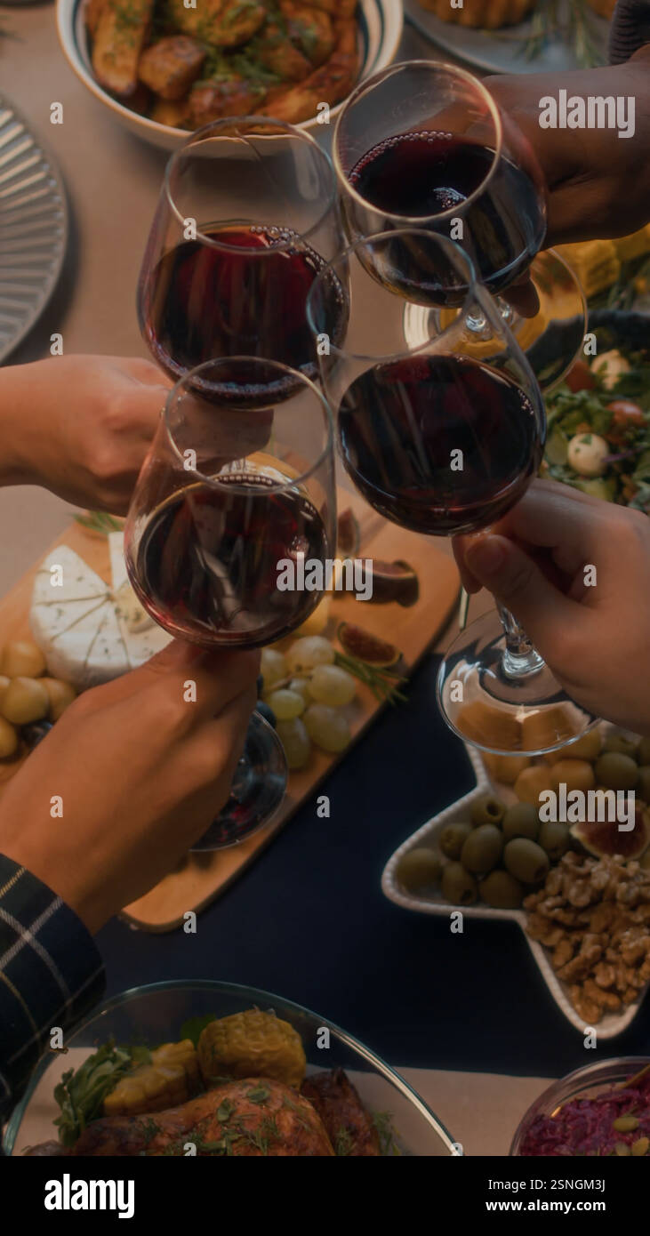 Vertical of Four People Toasting with Red Wine Glasses at Cozy Dinner ...