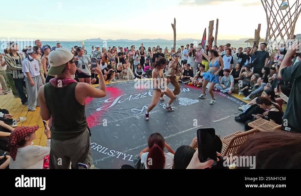 Dance battle on an outdoor stage by the sea with an energetic crowd ...
