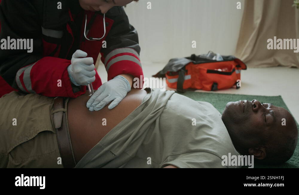 Paramedic Injecting Medication into Stomach of Unconscious Patient ...