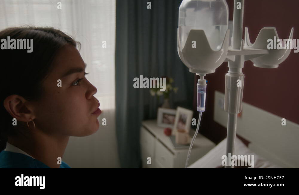Nurse Attaching IV to Patient, Lying in Ward Bed with Oxygen Mask and ...