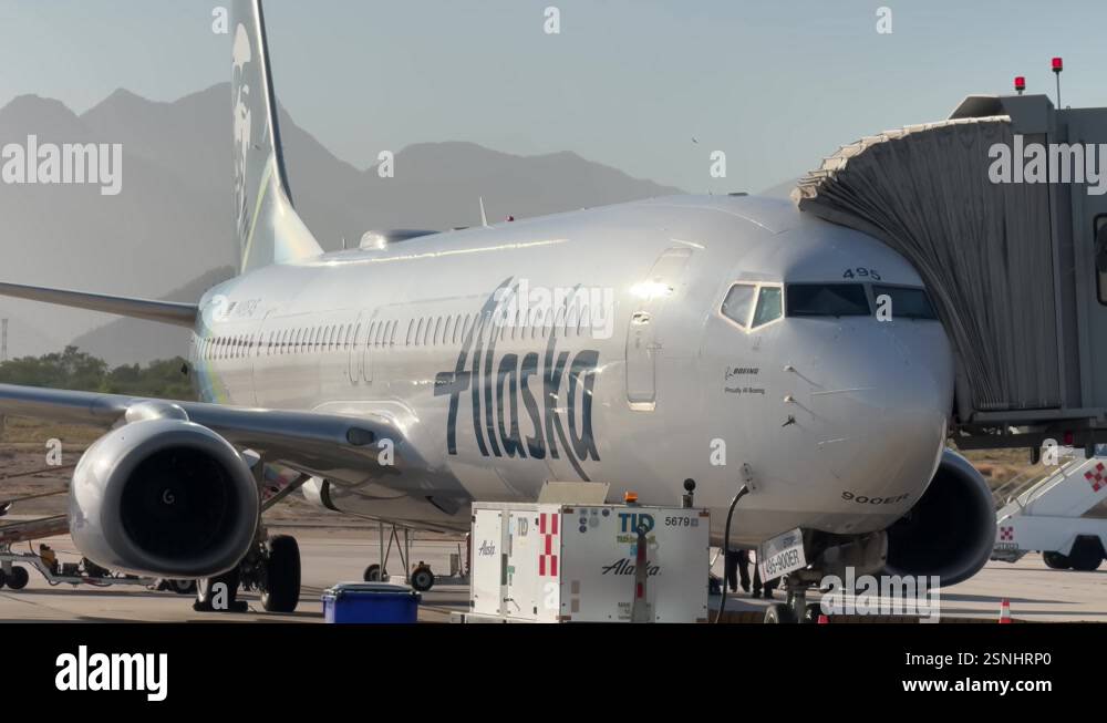 An Alaska Airlines Boeing 737-900ER aircraft parked at a gate, with a ...