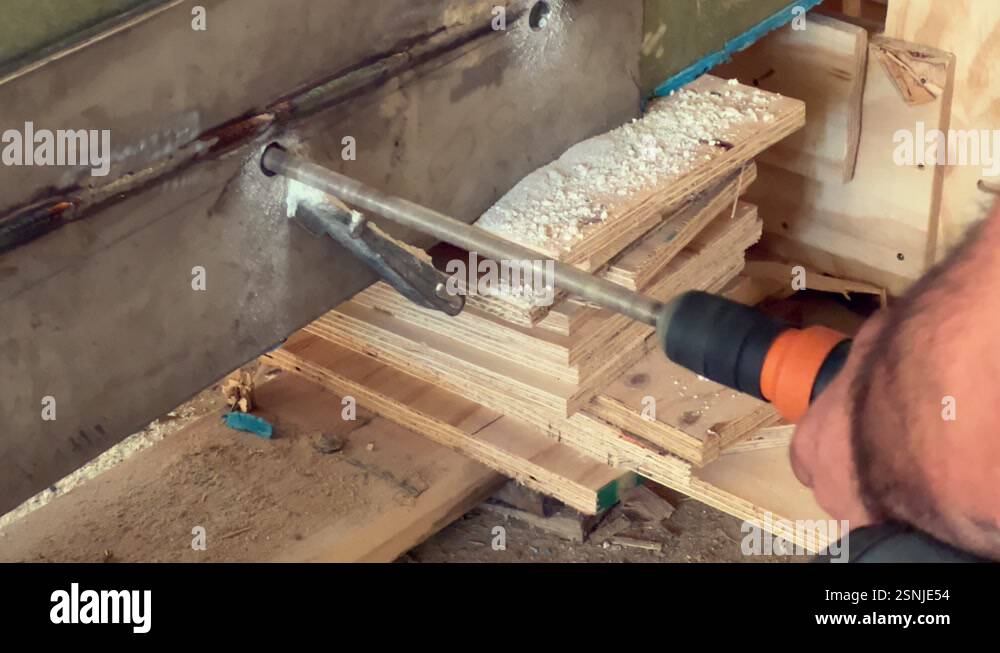 Carpenter using reciprocating saw to remove old formwork during house ...