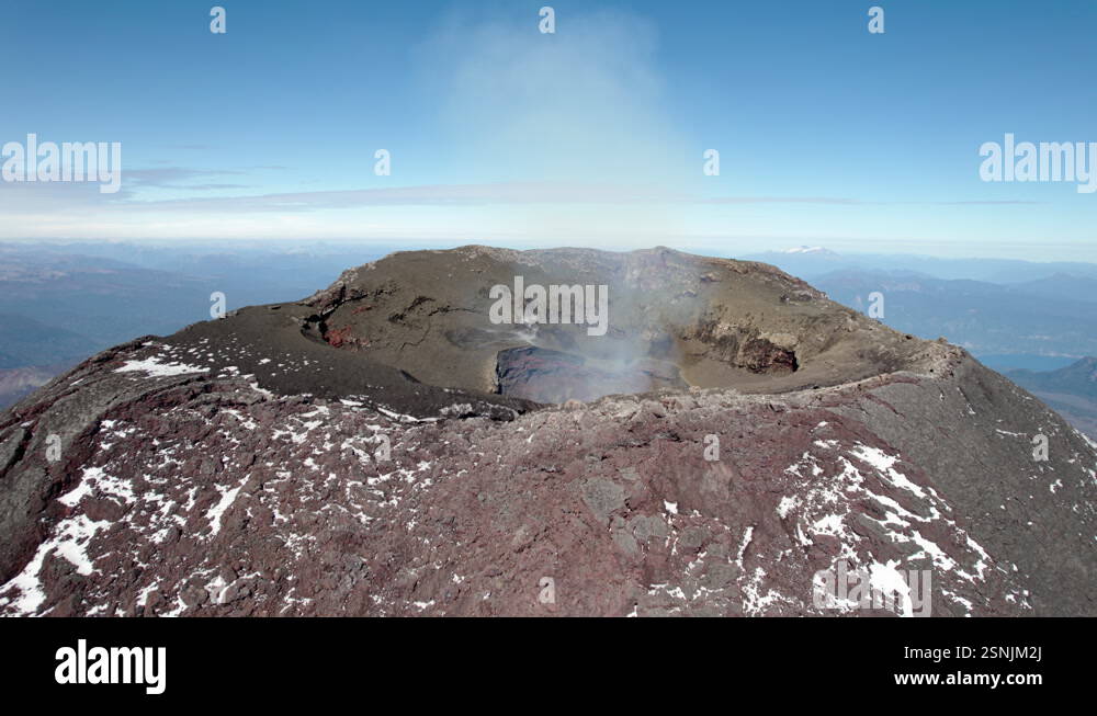 A breathtaking view from the summit of a volcano reveals a large crater ...