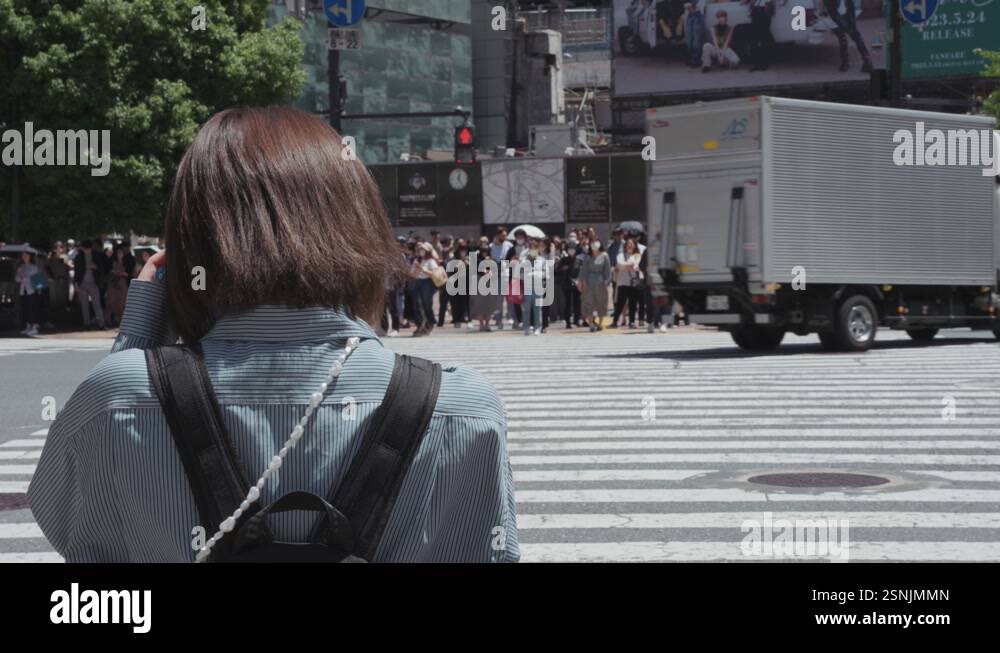 A bustling daytime video of crossing the famous Shibuya crosswalk in ...