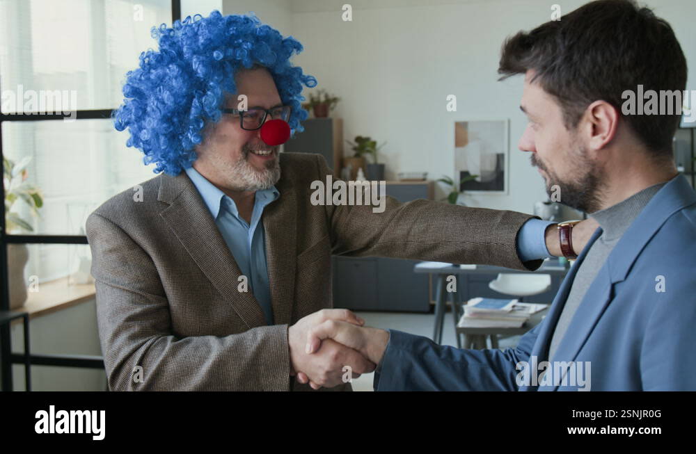 Cheerful CEO with Clown Wig and Nose Giving Handshake to Employee in ...