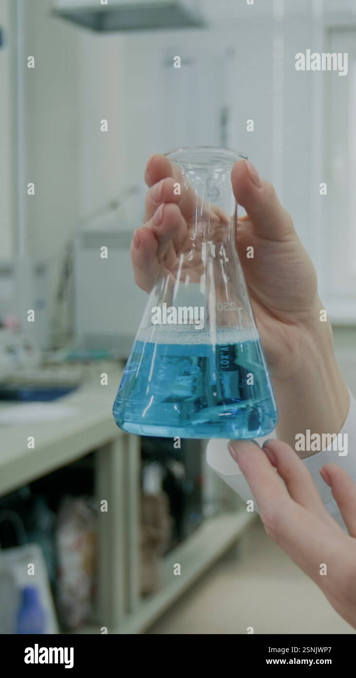 Hands of Unrecognisable Chemist Analysing Blue Substance Holding Flask ...
