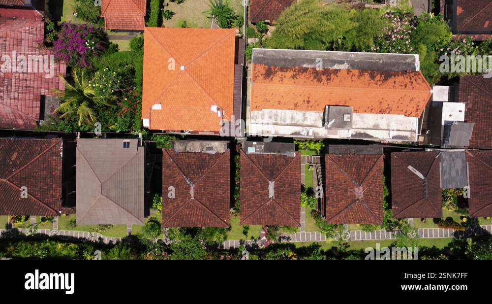 Drone top-down pan across Ubud neighborhoods with rooftops and tropical ...