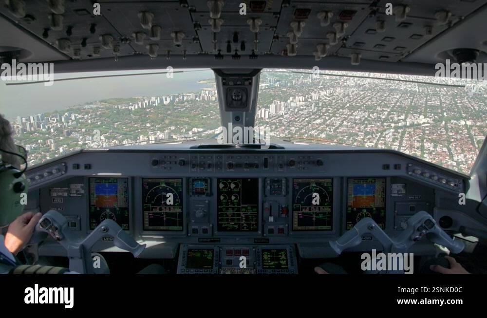 Airplane cockpit view during approach over a city with clear skies and ...