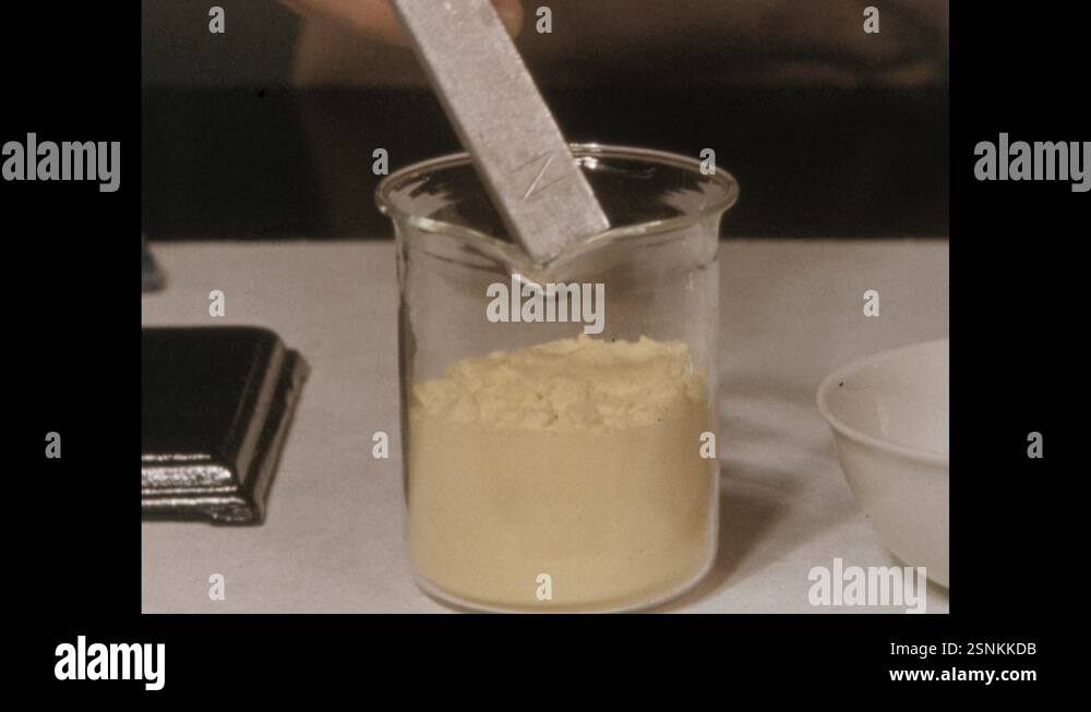 1960s: Magnet inserted into beaker half-filled with dry substance Stock ...