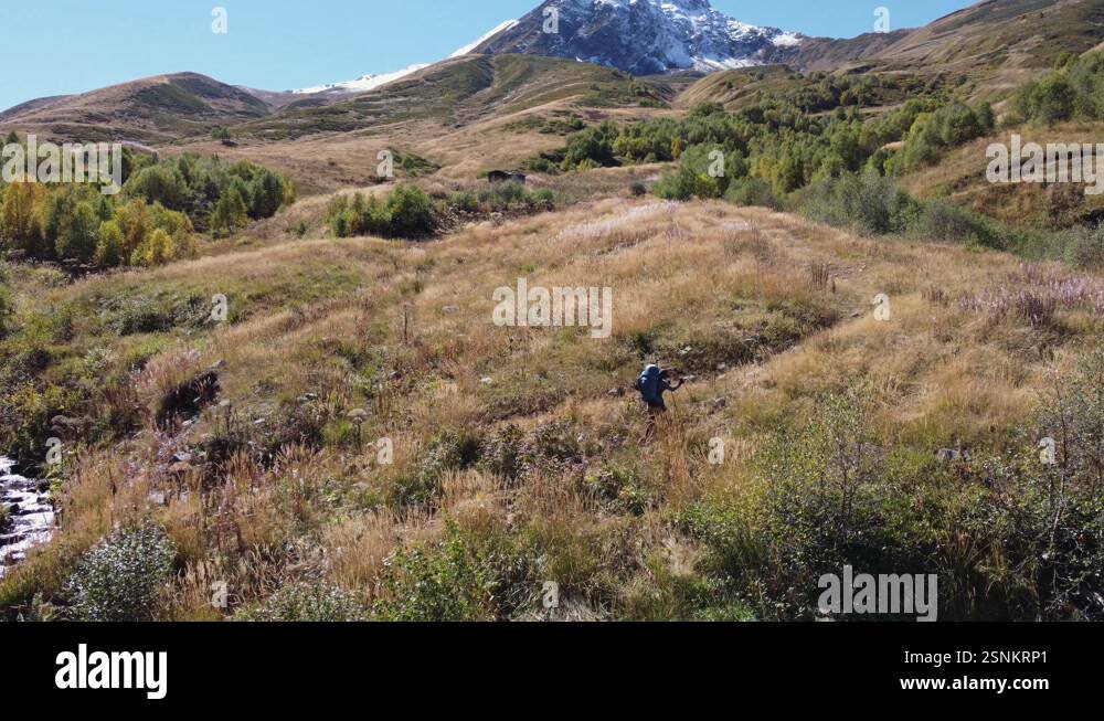 Hiker with heavy backpack walks rugged Transcaucasian Trail in Georgia ...