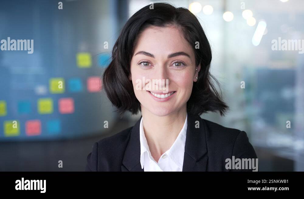 Smiling woman in professional business attire looking confidently at ...