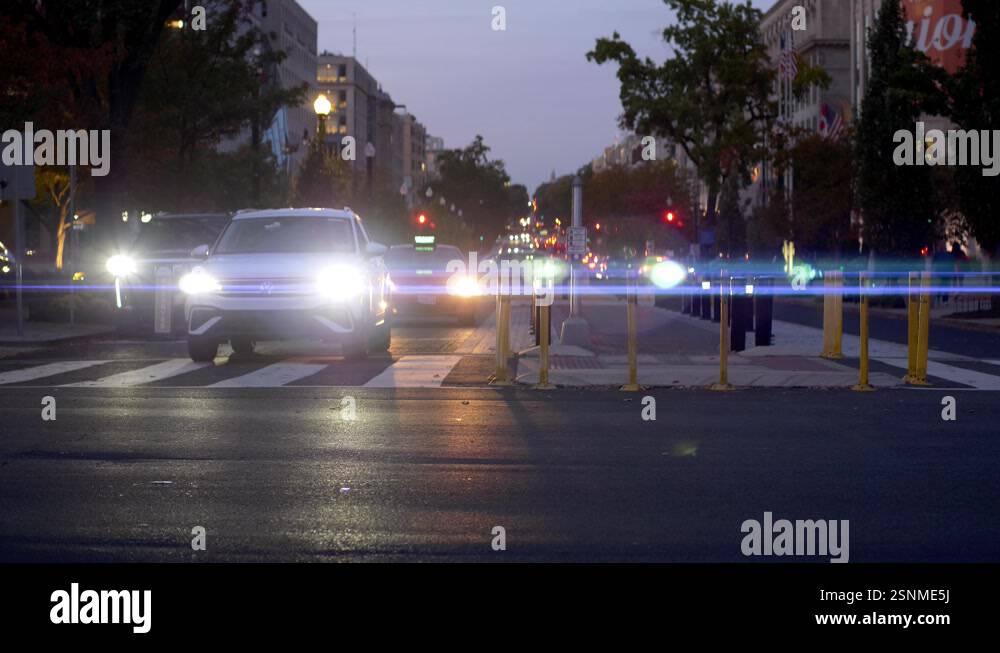 Anamorphic shot of cars turning along a street in downtown Washington ...