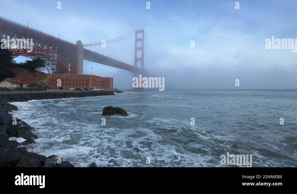 Foggy mist Golden Gate Bridge surf wave crash on rocks San Fransisco ...