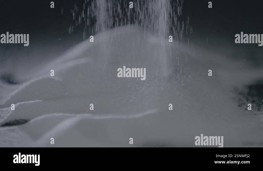 Sugar granules falling in slow motion creating a soft pile under ...