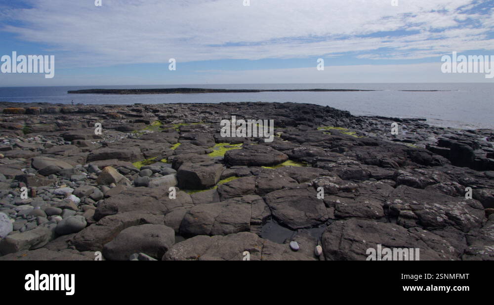 Extra wide shot looking over Craster exposed rocks at low tide with ...