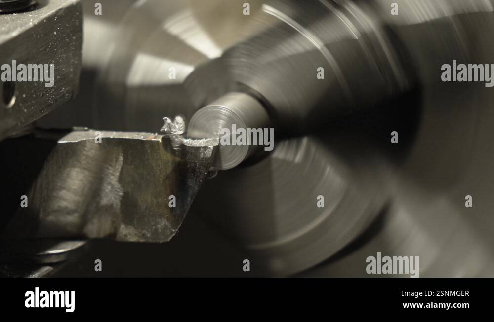 The metalworking process highlights a lathe skillfully shaping a metal ...