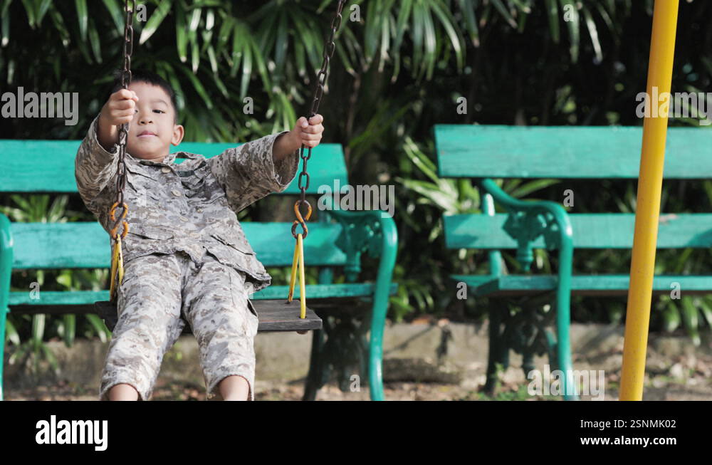 Little asian boy enjoy play swing bar outdoor playground city public ...