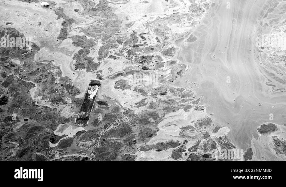 Contaminated water surface with visible pollution, debris, and swirling ...