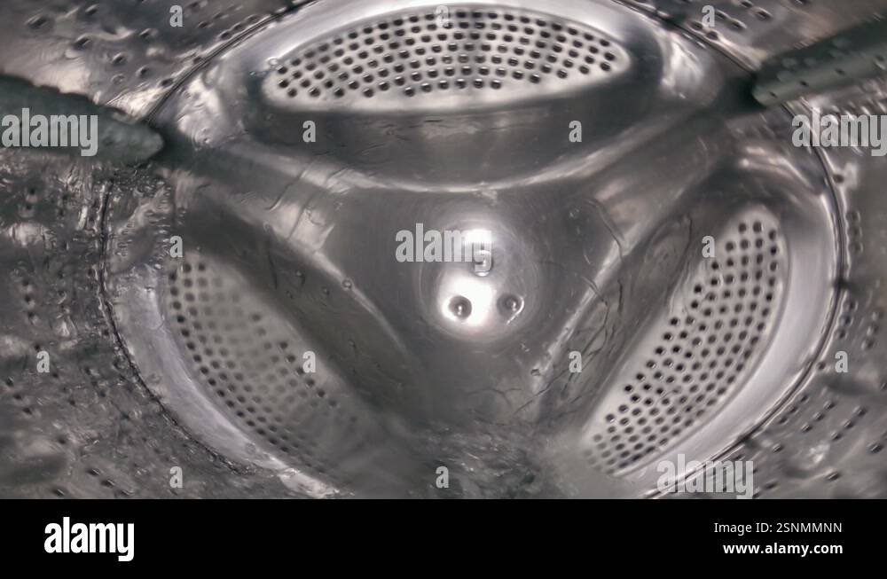 The inside of washing machine drum with perforated metal surface and ...