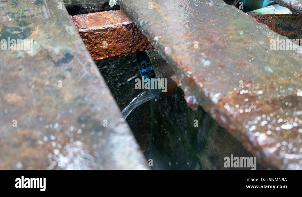 Drainage water pouring down from pipe to street underground sewage dump ...
