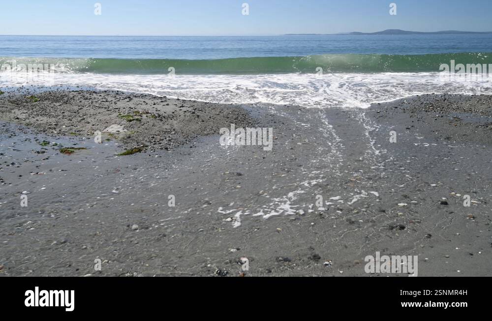 Sea water being swept onto beach by successive breaking waves Stock ...